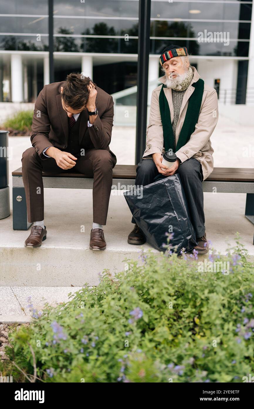 Full length vertical portrait of chatting businessman and old homeless ...