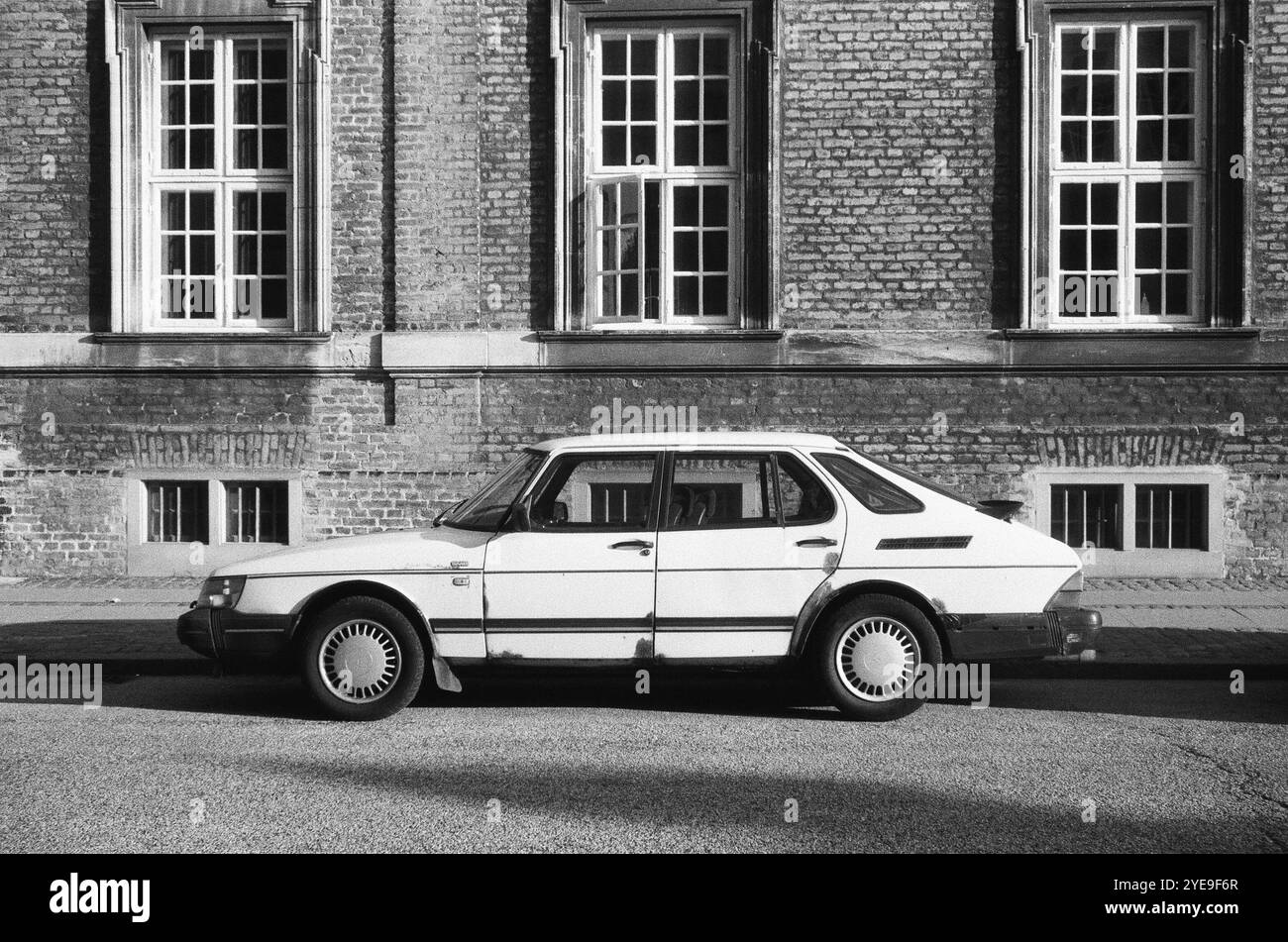 Vintage Saab parked along a historic brick building with large windows ...