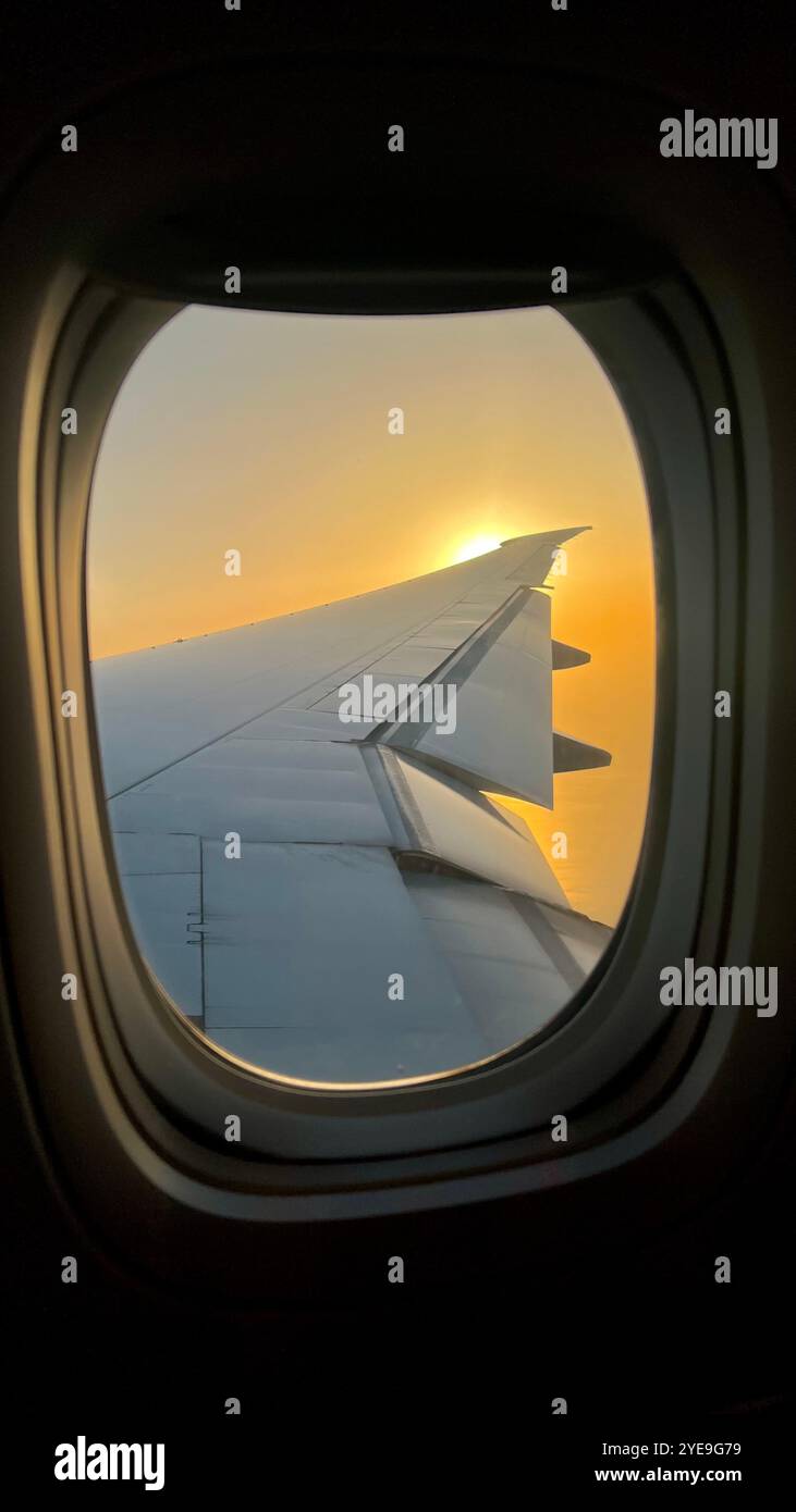 Sunrise out airplane window looking over wing Stock Photo - Alamy