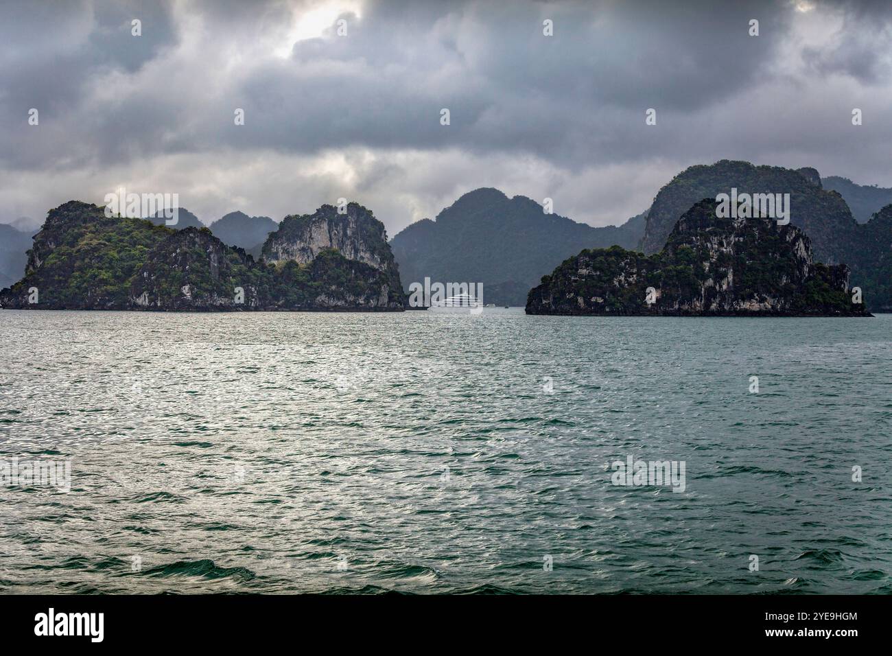 Ship sailing between karst rock formations at Ha Long Bay in Vietnam ...