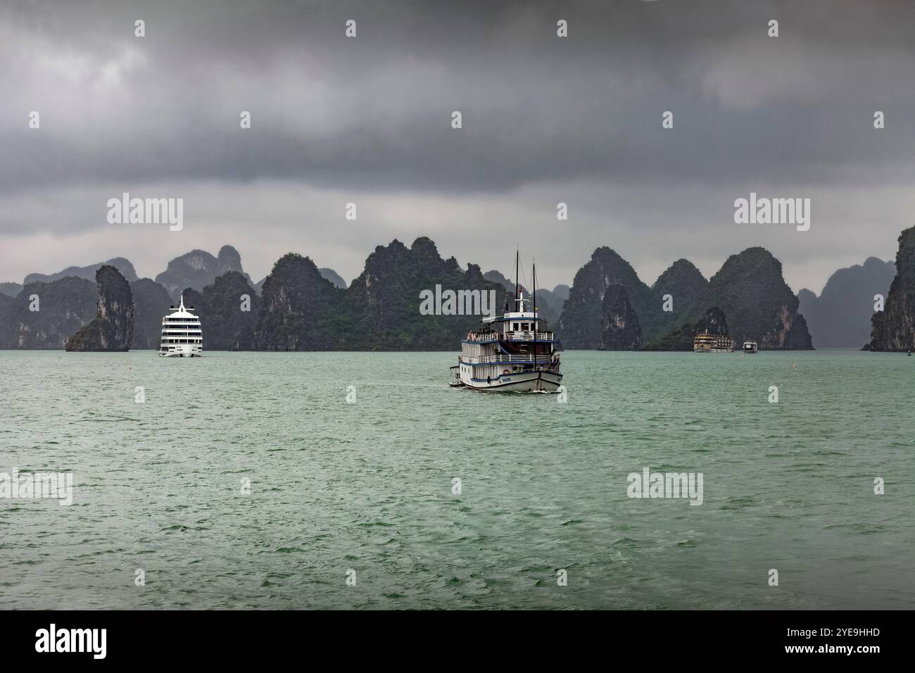 Ship sailing between karst rock formations at Ha Long Bay in Vietnam ...