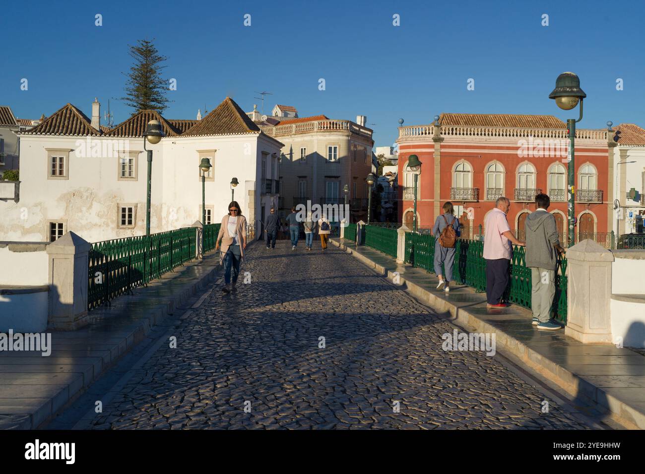 Pedestrians on a footbridge over the Gilao River in the town of Tavira ...