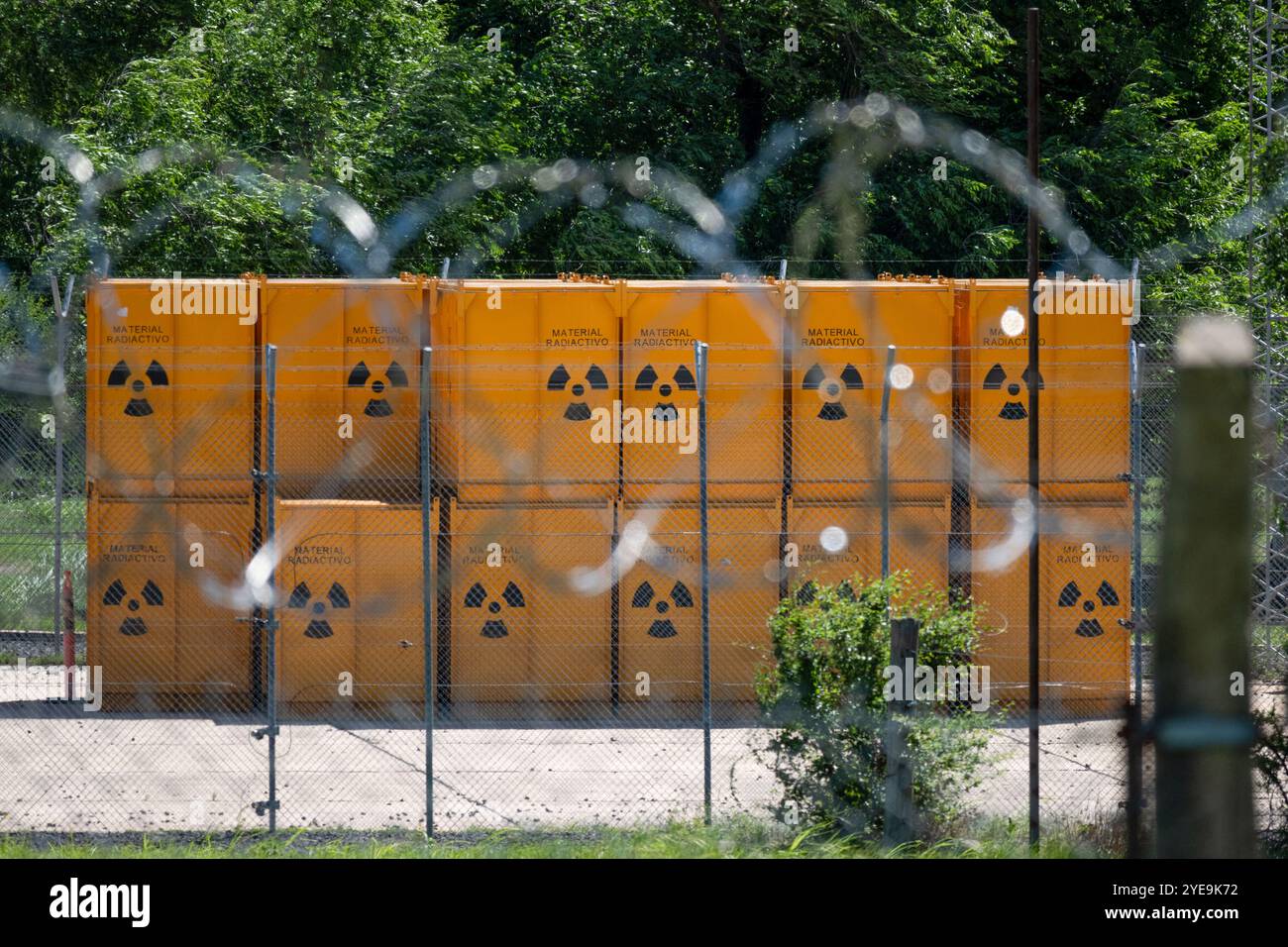 Group of yellow barrels stacked with radioactive waste, behind a ball ...