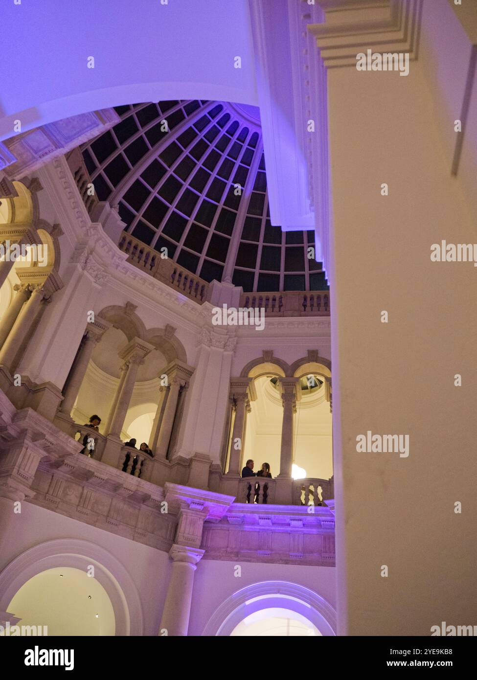 Low angle view of the glass dome with purple lighting and tourists at ...