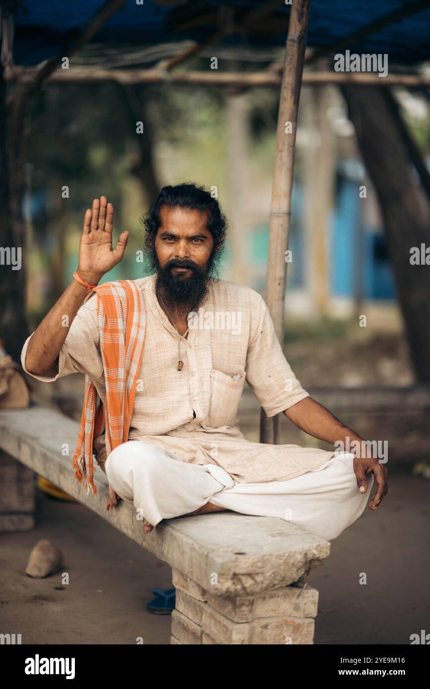 Portrait of a mid adult man in traditional indian clothing sitting ...