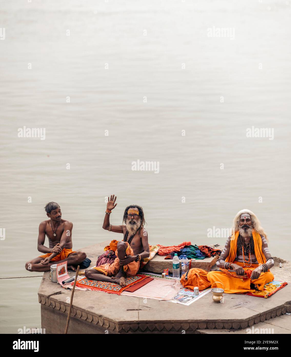 Three Hindu men sitting along the Ganges in Varanasi, India; Varanasi ...