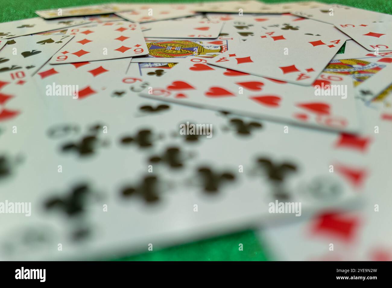 Close-up of playing cards on a playing table with a shiny green cloth ...