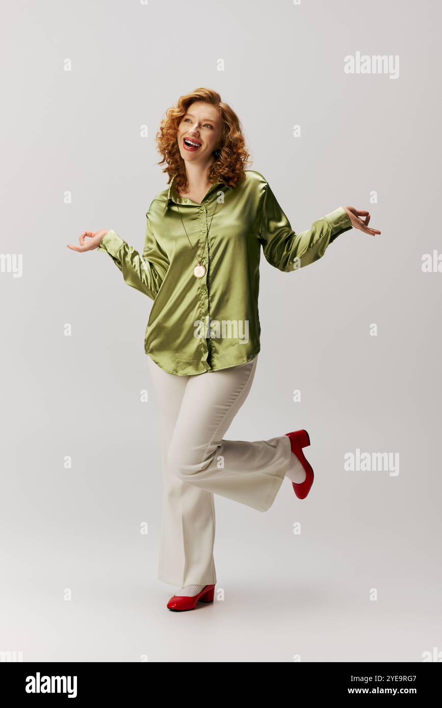 A cheerful young woman with a playful stance and a bright smile Stock ...