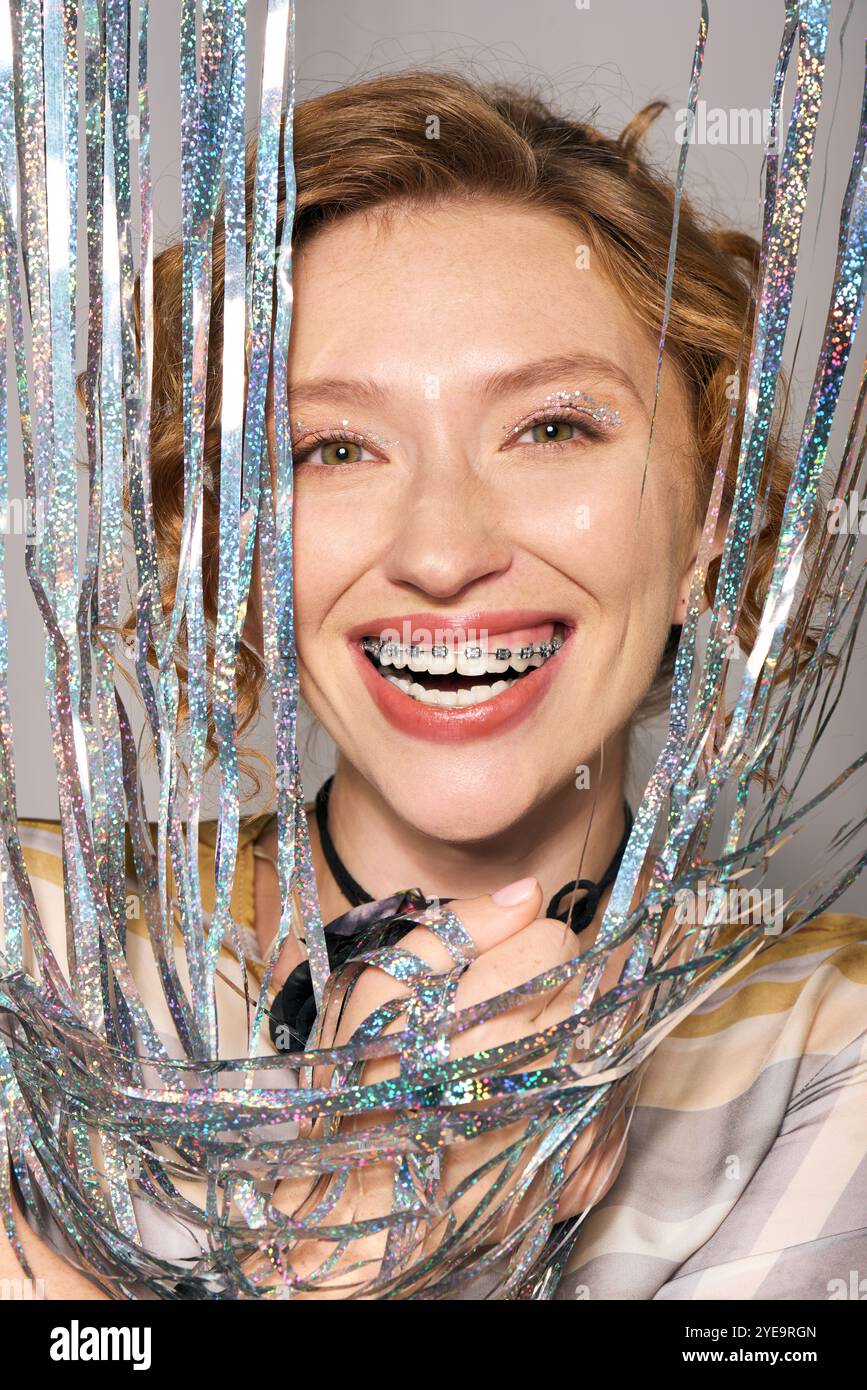 A cheerful young woman smiles broadly while playfully surrounded by ...