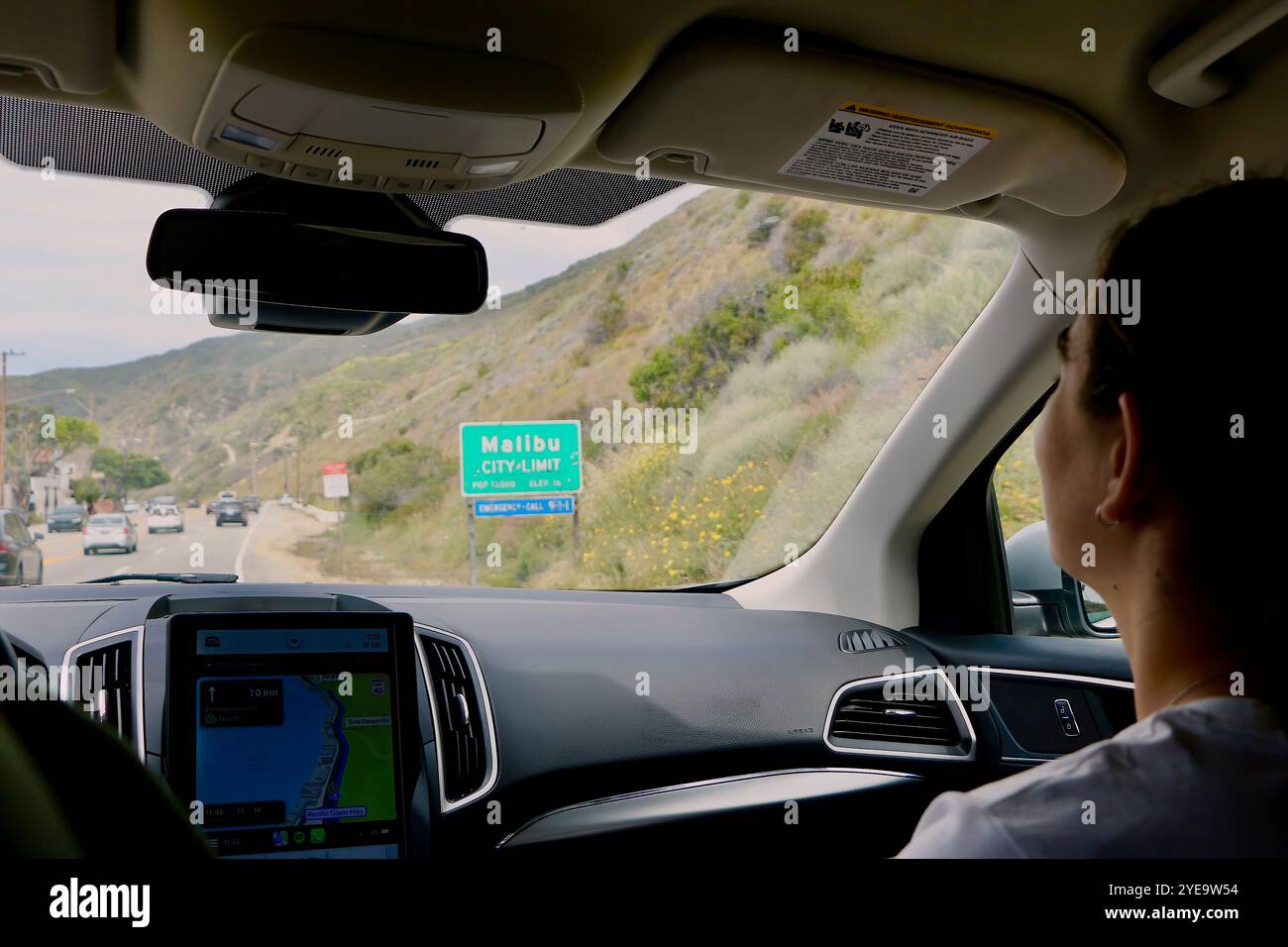 View from inside a car passing the road sign for Malibu City Limit ...