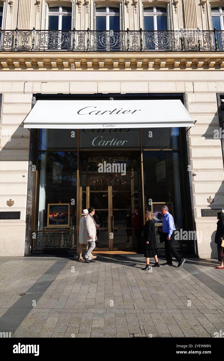 People walking by the Cartier store on the Champs Elysees in Paris ...