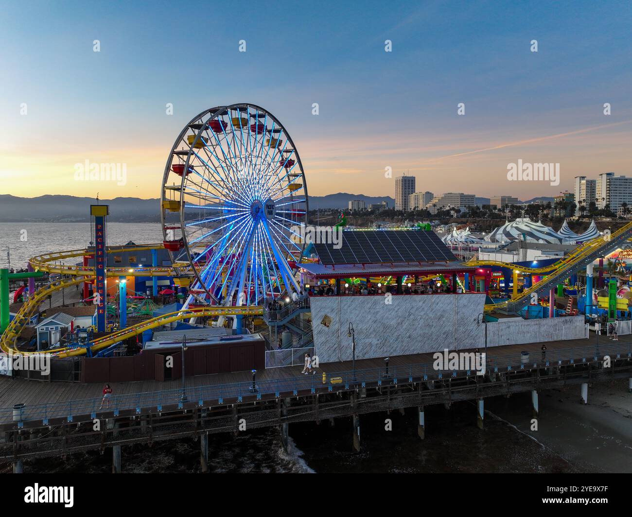 The Santa Monica Beach Pier in California, with Pacific Park at Sunset ...