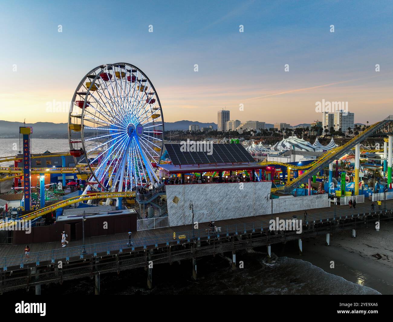 The Santa Monica Beach Pier in California, with Pacific Park at Sunset ...