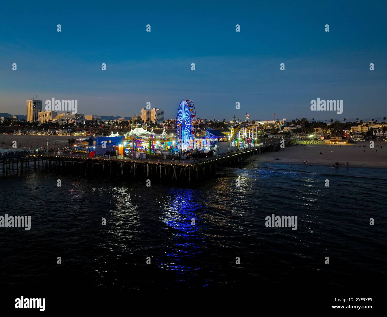 The Santa Monica Beach Pier in California, with Pacific Park at Sunset ...