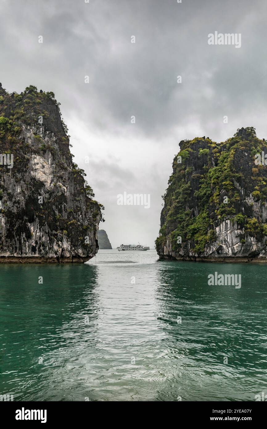Ship sailing between karst rock formations at Ha Long Bay in Vietnam ...
