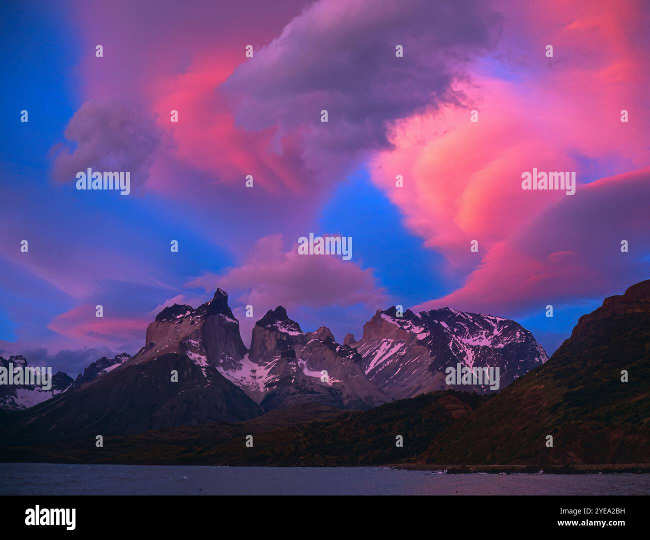 Sunset light glowing pink in the clouds over Cuernos del Paine in ...