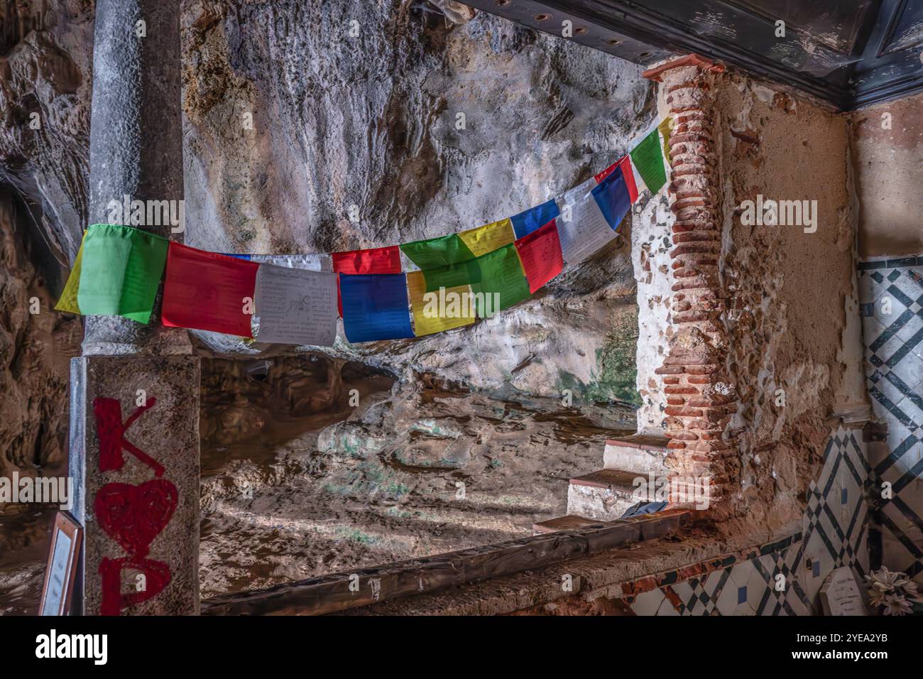 Buddhist prayer flags and grafitti in the historic Santa Margarida cave ...