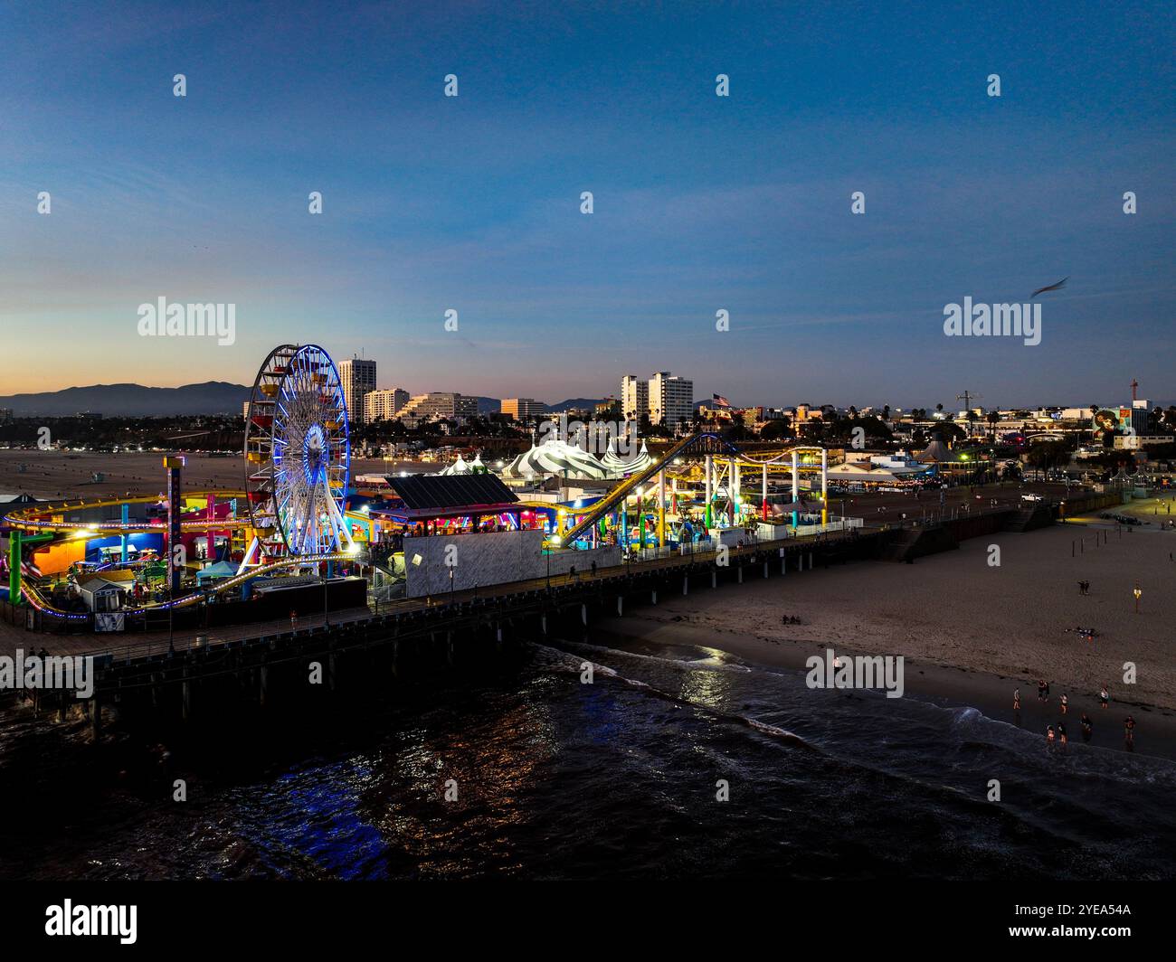 The Santa Monica Beach Pier in California, with Pacific Park at Sunset ...