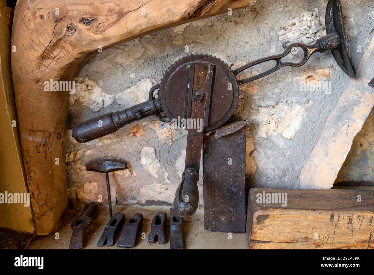 A vintage wheel brace hand drill, a bradawl, and hammer heads on a ...