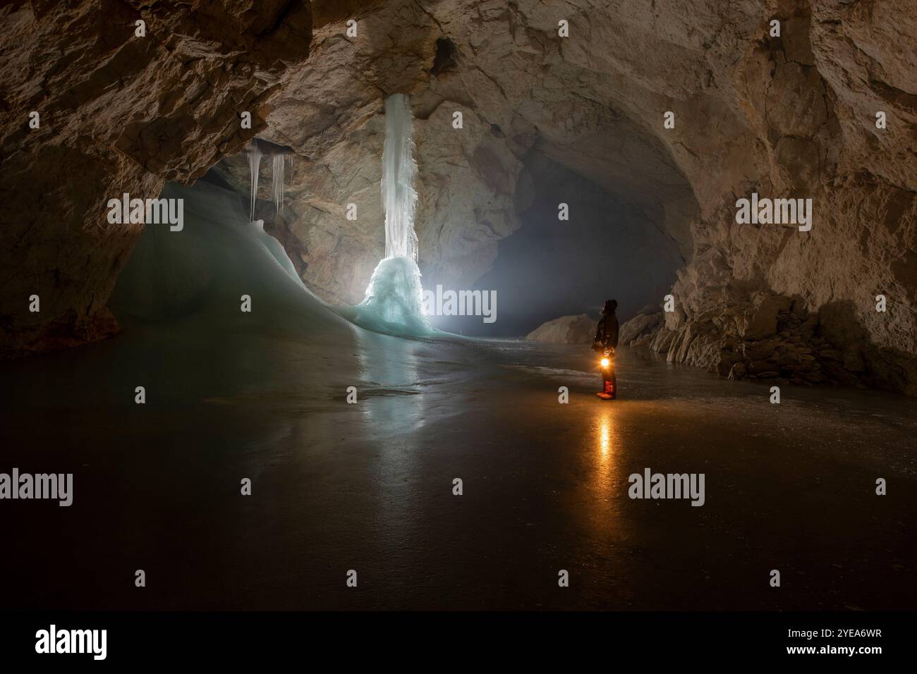 Person standing inside the illuminated ice cave of the Eisriesenwelt ...