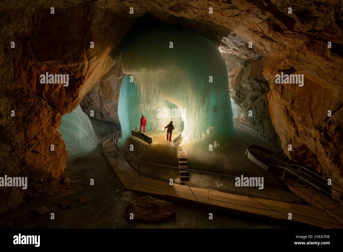 People standing inside the illuminated ice cave of the Eisriesenwelt ...