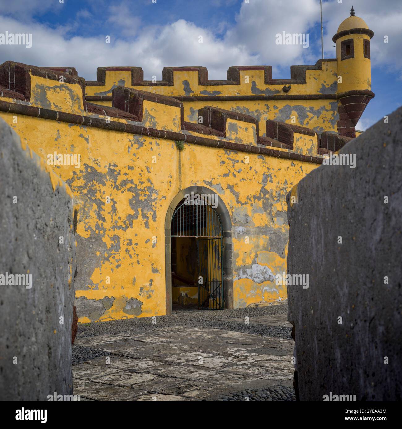 Weathered facade of the yellow architecture of the Fort of Sao Tiago in ...