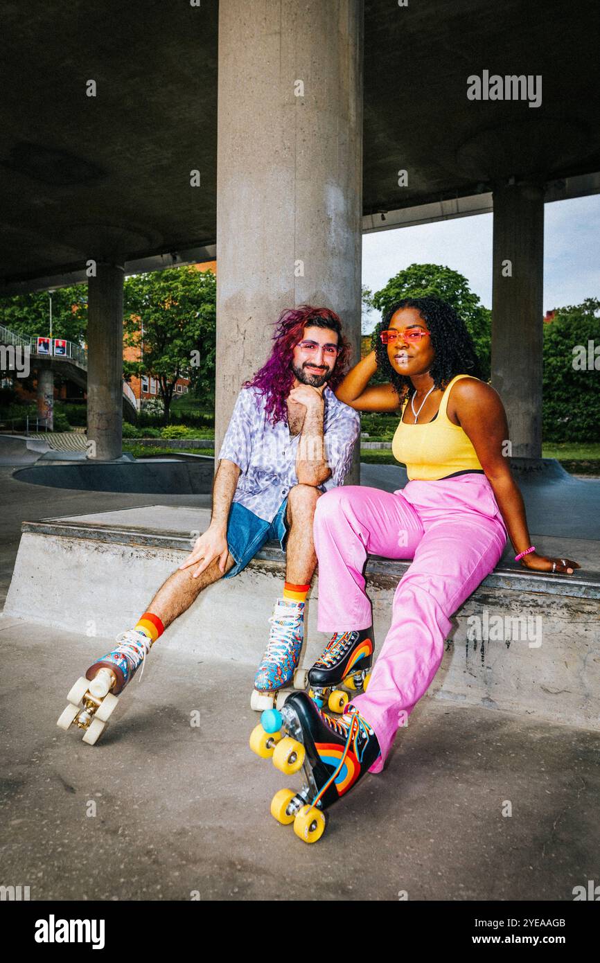Portrait of confident male and female friends wearing roller skates ...