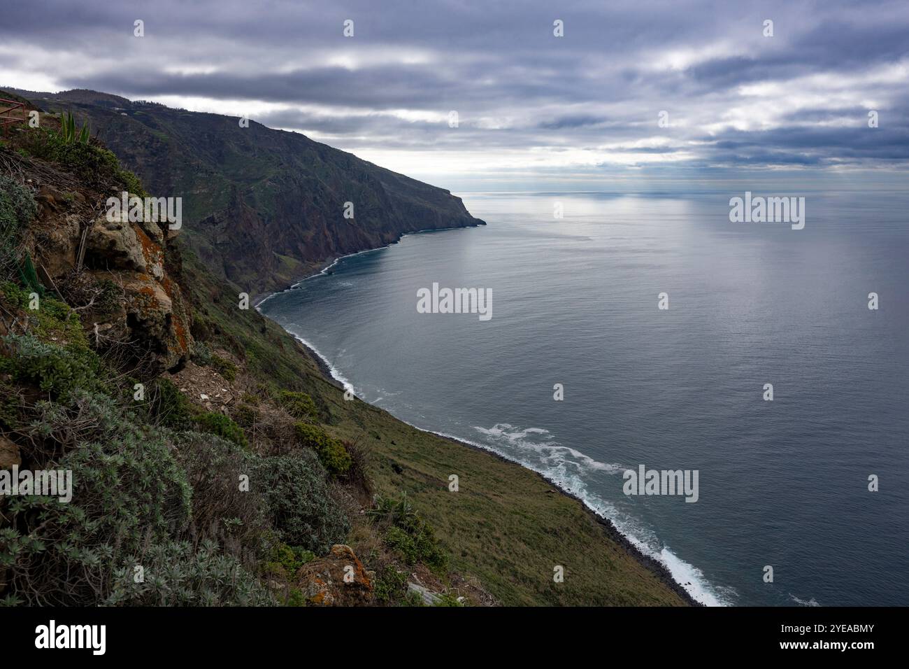 Rugged sea cliffs and ocean view with grey, cloudy sky from Farol da ...