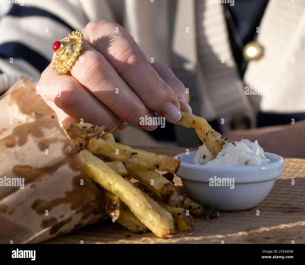 Woman's hand dipping a french fry into a sauce; Madeira, Portugal Stock ...