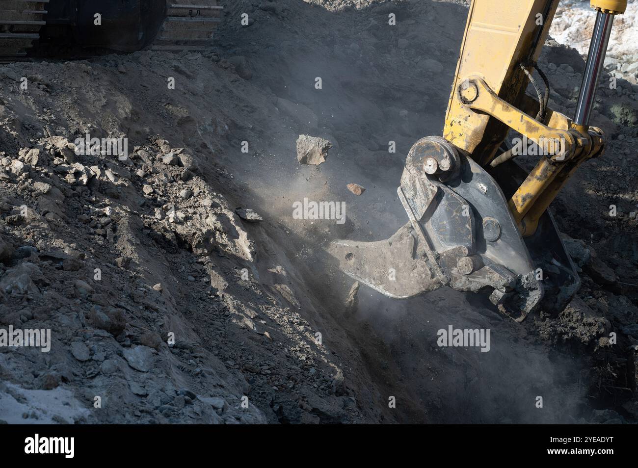 A ripper that tears up frozen ground in winter, with stones flying ...