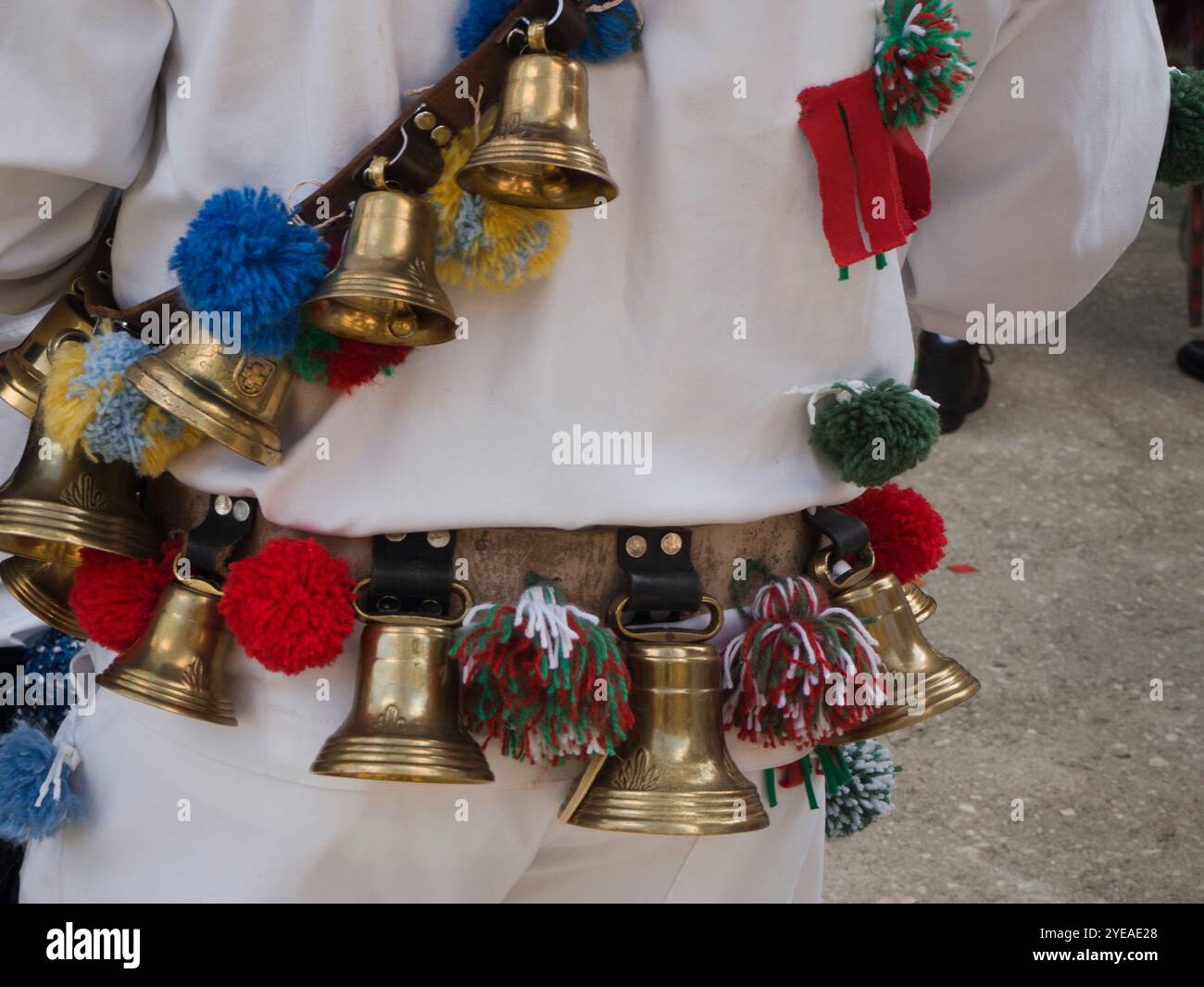 Small decorative brass bells and pom poms decorating a costume at the ...