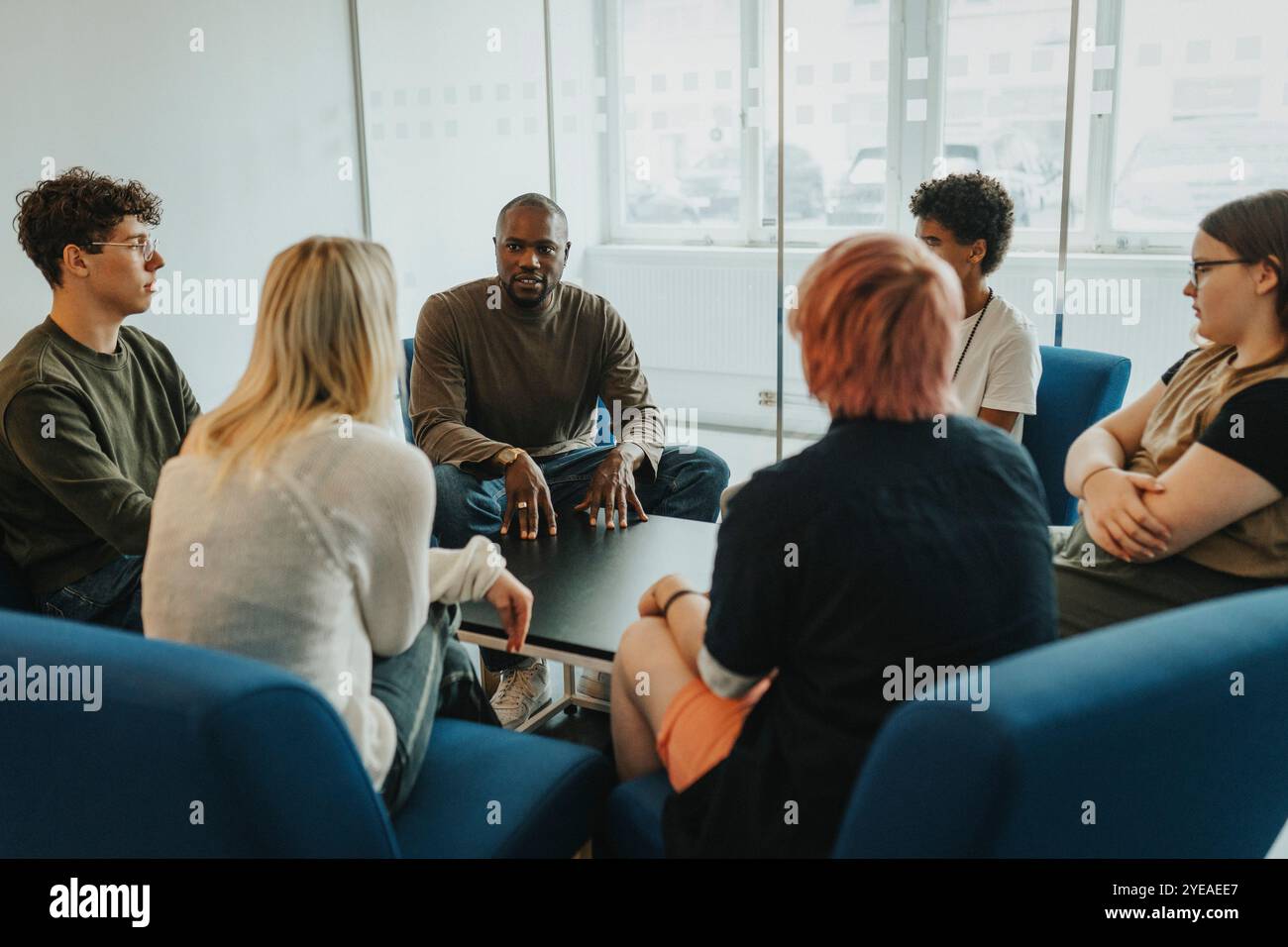 Mental health professional discussing with male and female students ...