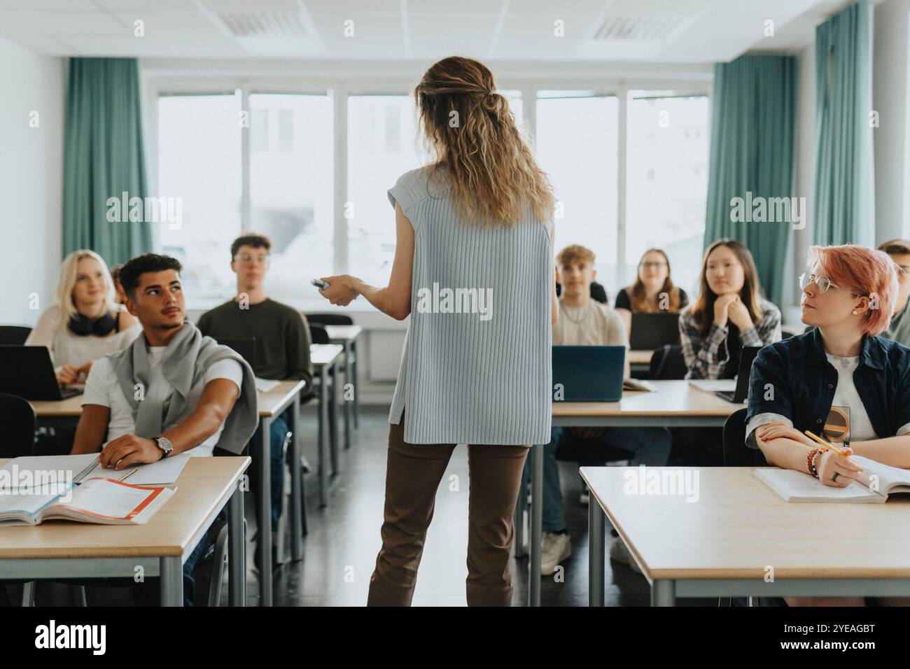 Rare view of teacher explaining male and female students in classroom ...