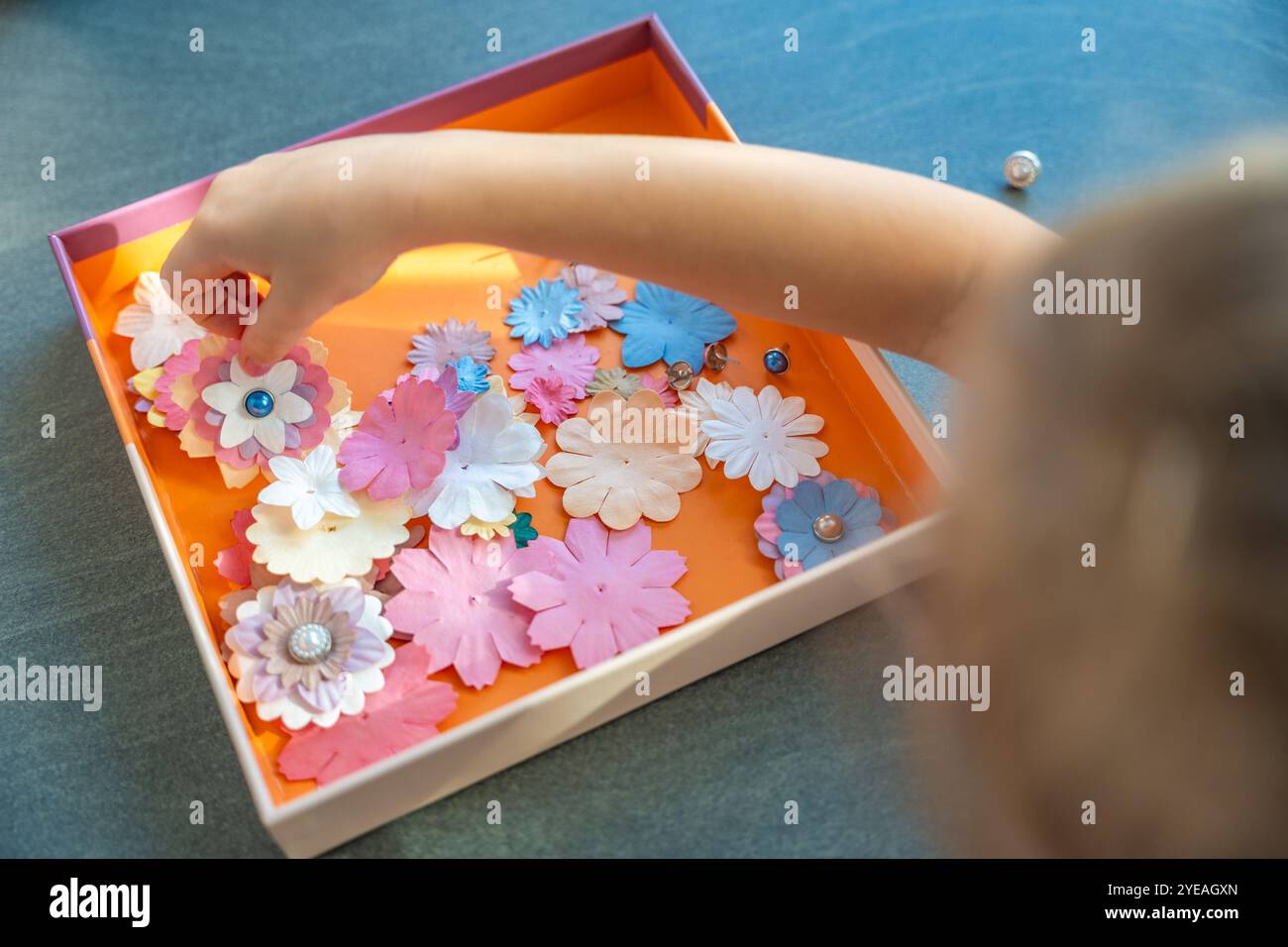 Small, colorful paper flowers in child hands, little girl creativing of ...