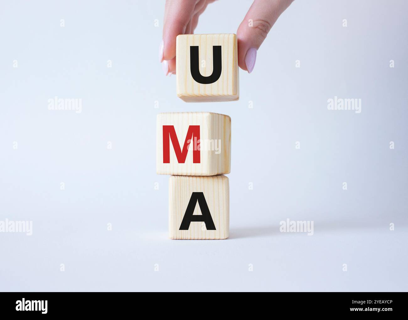 UMA - Unified Managed Account. Wooden cubes with word UMA. Businessman ...
