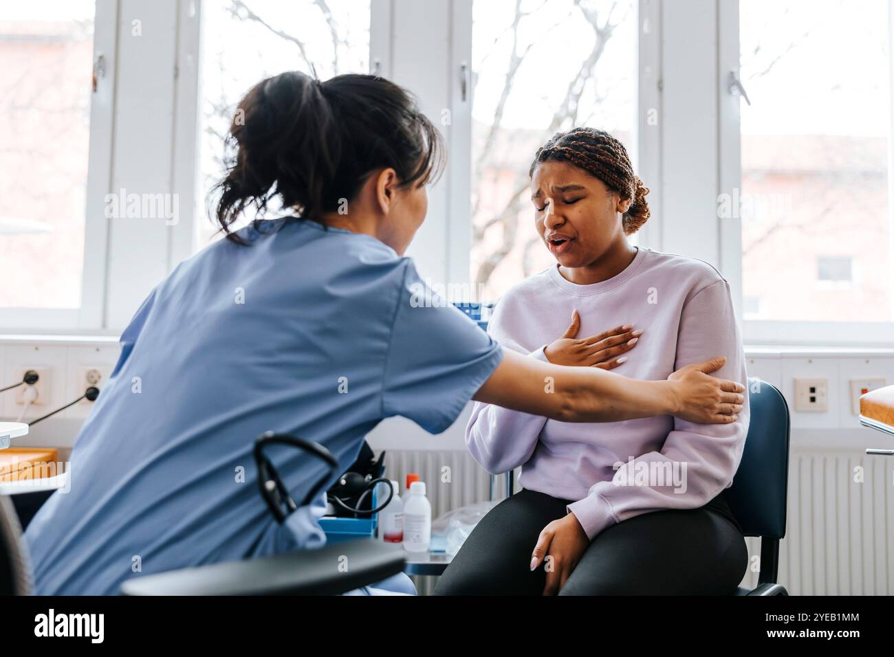 Female medical expert consoling anxious patient with hand on chest ...