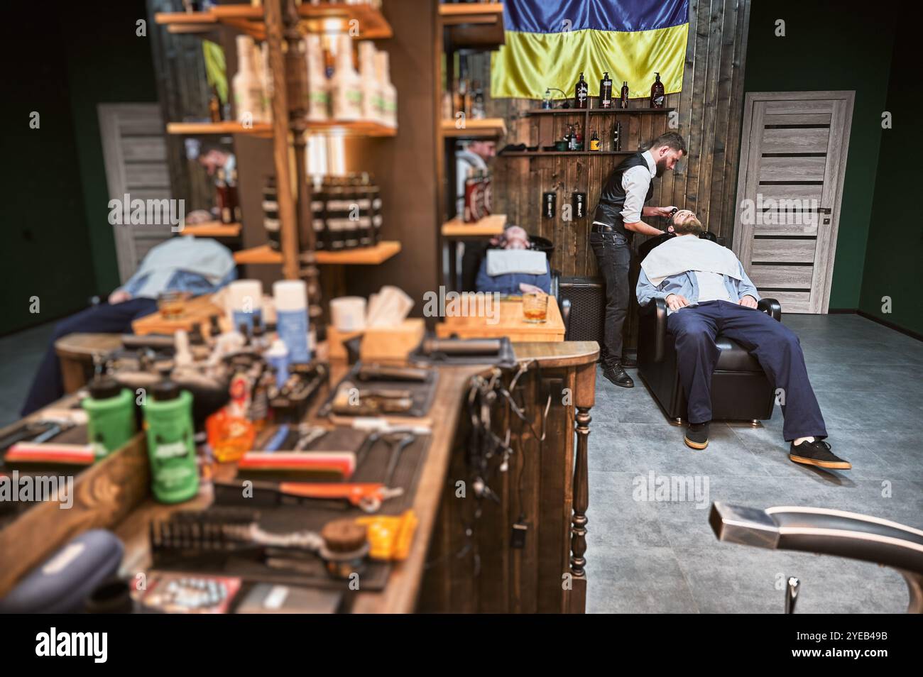 Professional barbers washing hair with deep cleaning shampoo. Busy day ...