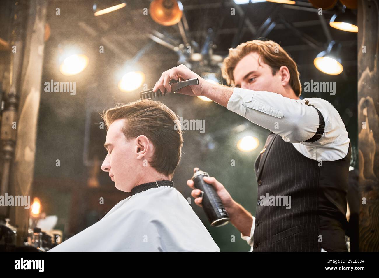 Professional barber using hairspray styling hi-res stock photography ...