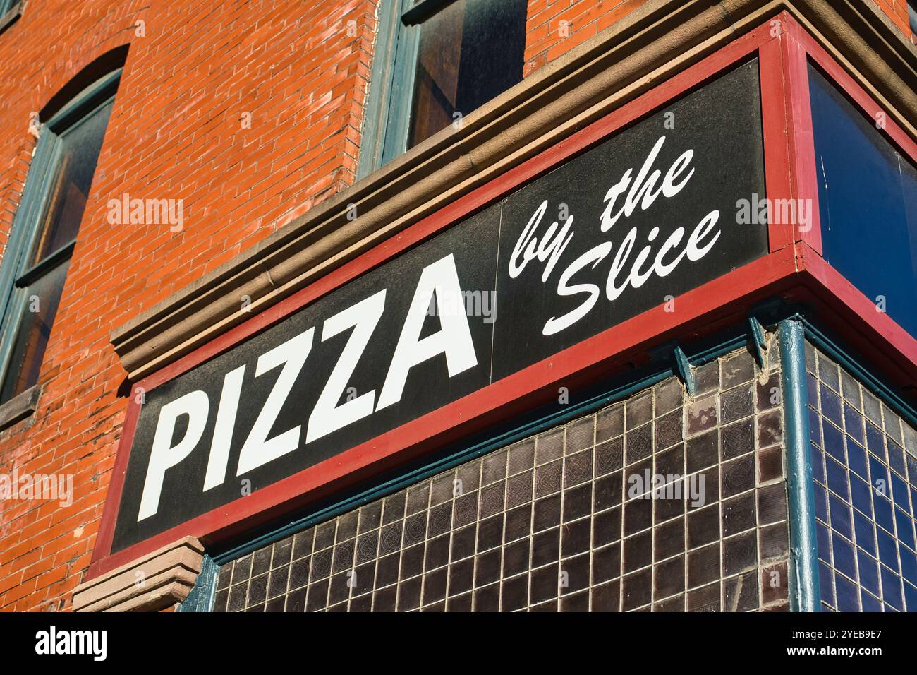 Unique Pizza by the slice sign above a pizza shop Stock Photo - Alamy