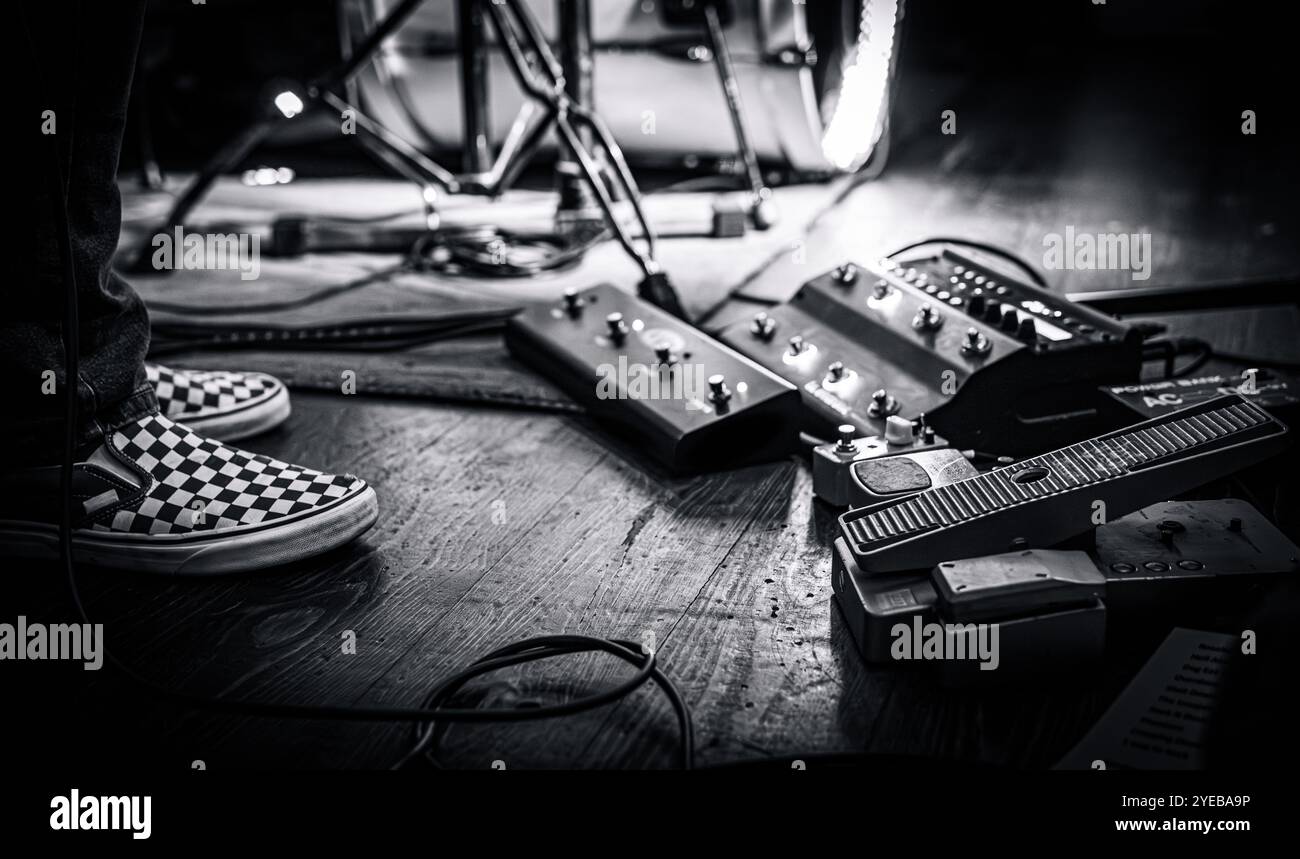 Guitarist pedalboard on a live concert stage next to his feet. Intimate ...