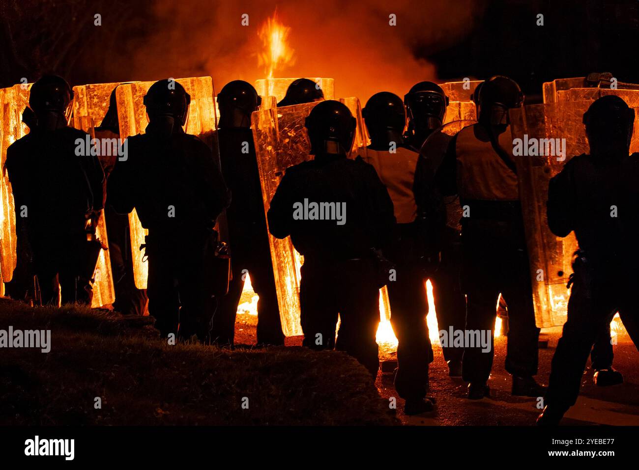 Police officers in riot gear respond to fiery rioting using petrol ...