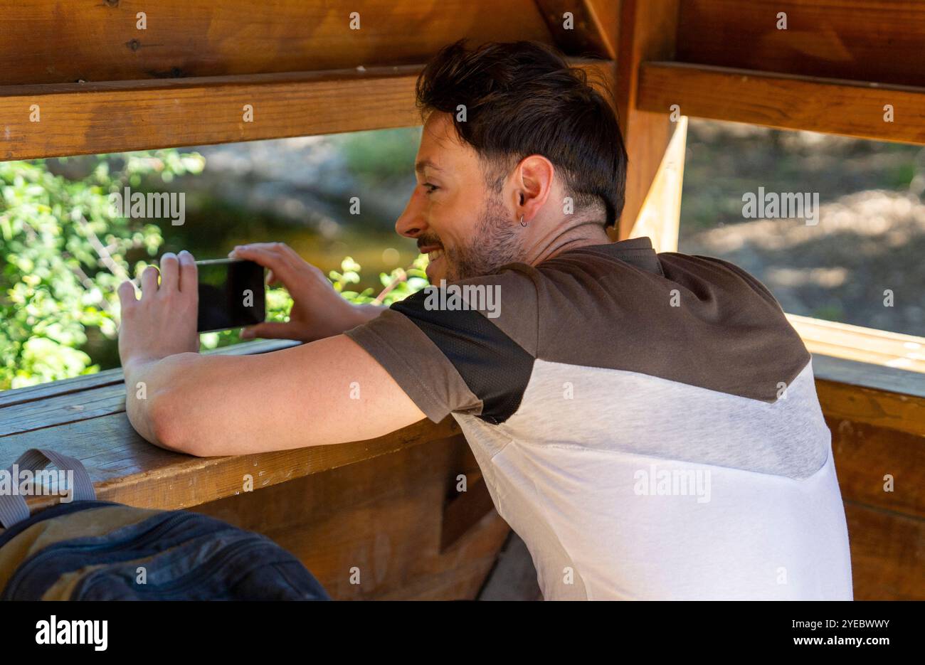 young adult taking a cell phone photo through an animal viewing ...