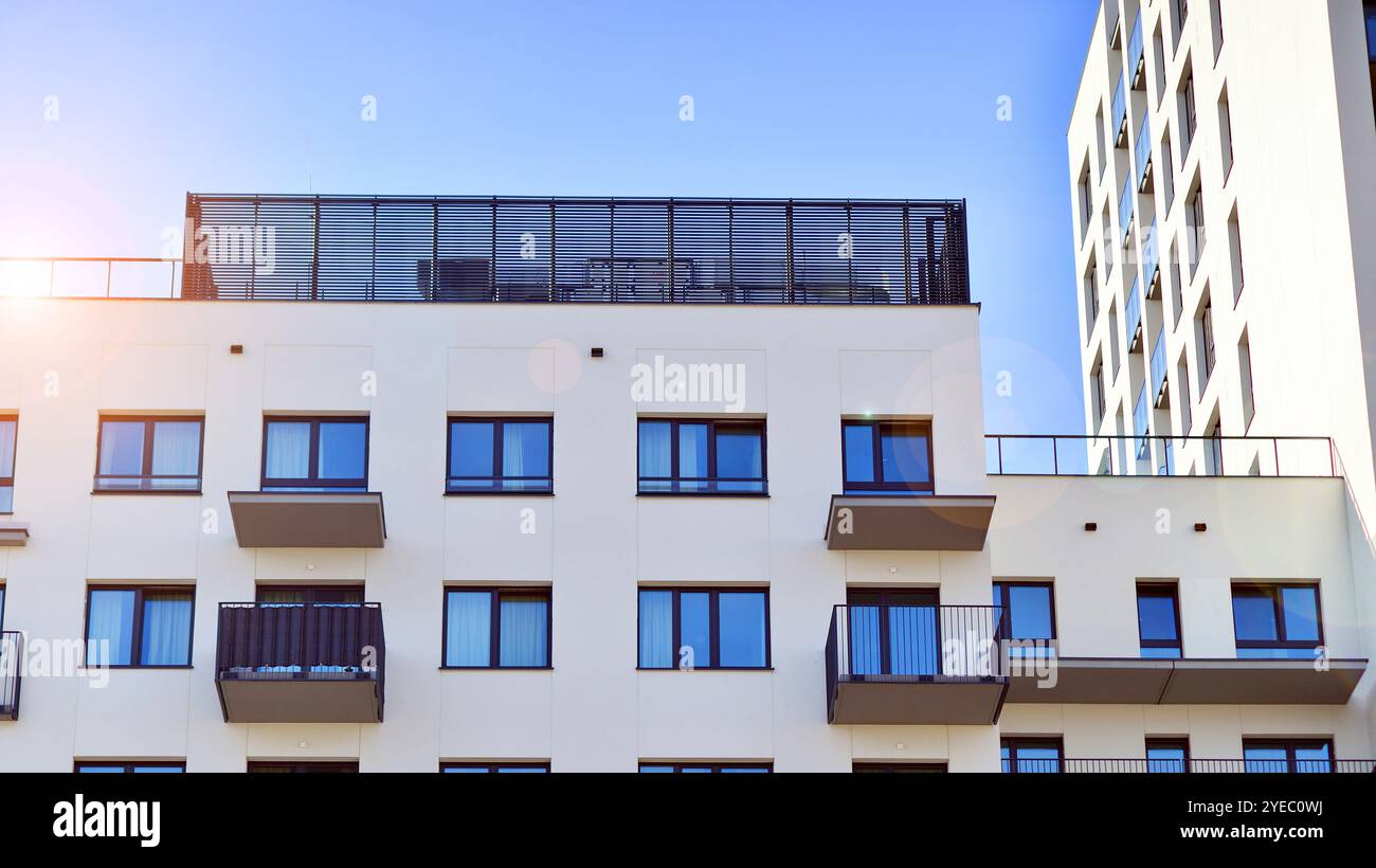 Modern high-rise apartment building in white, stand tall against a blue ...