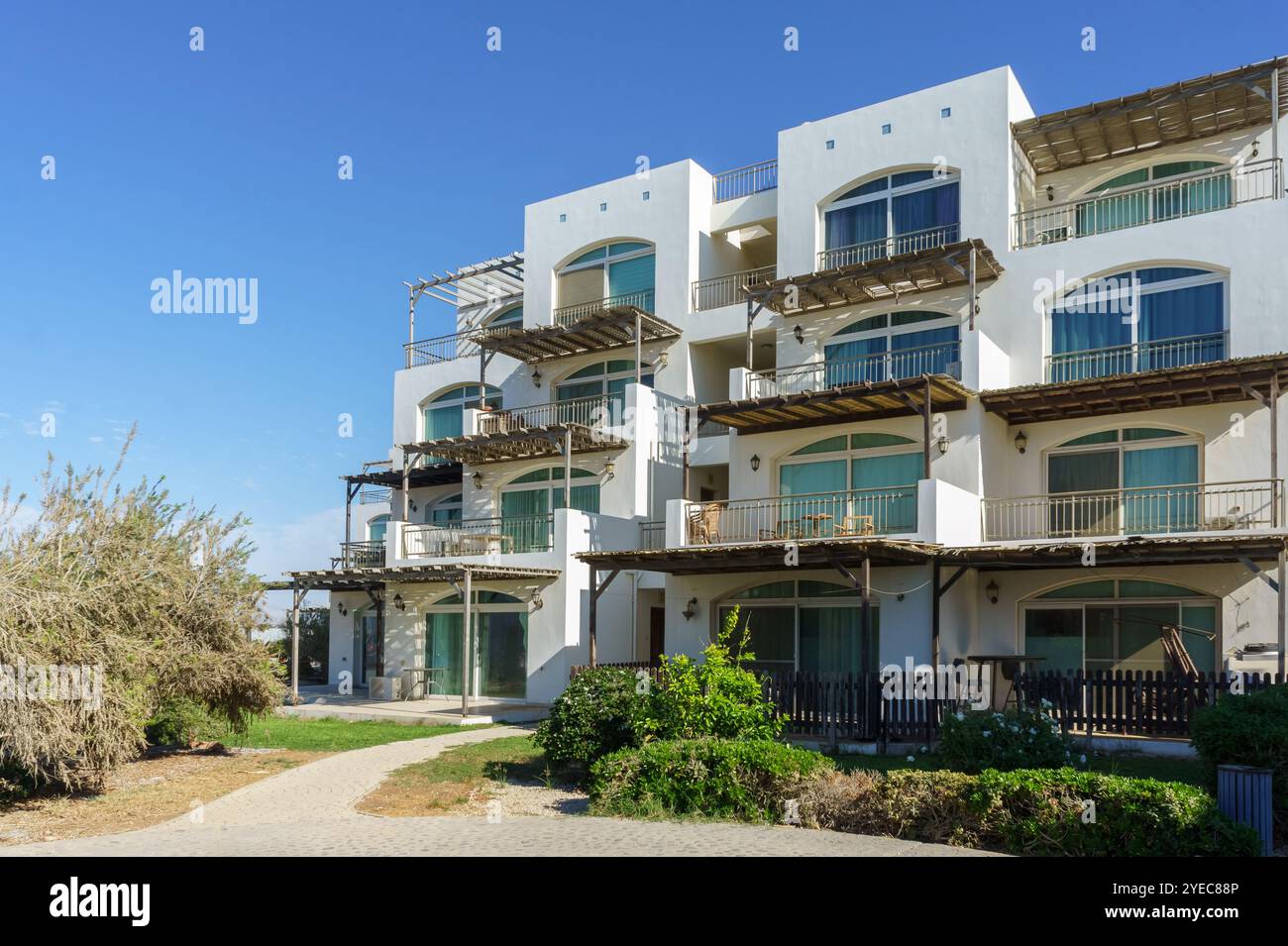 A lovely seaside resort showcases bright white buildings with balconies ...