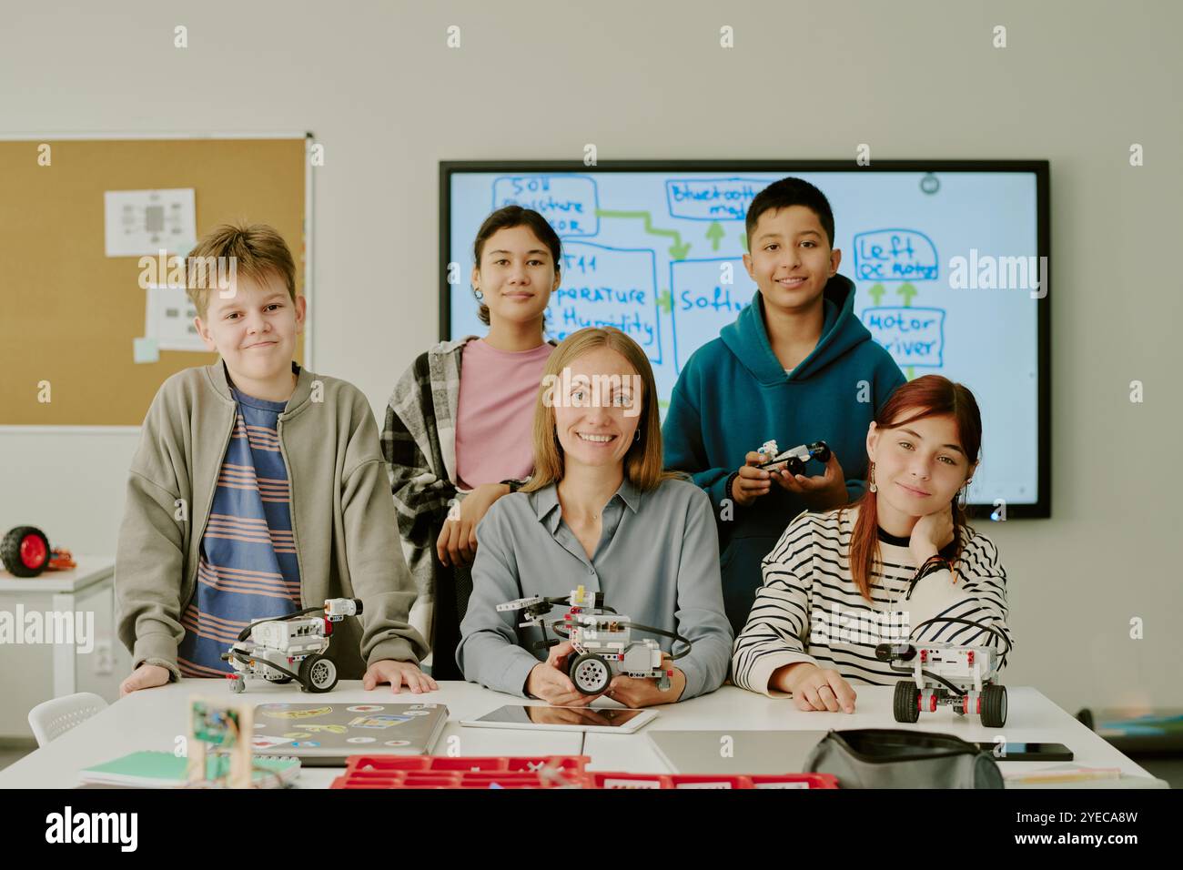 Portrait of multiracial students with their favorite robotics teacher ...