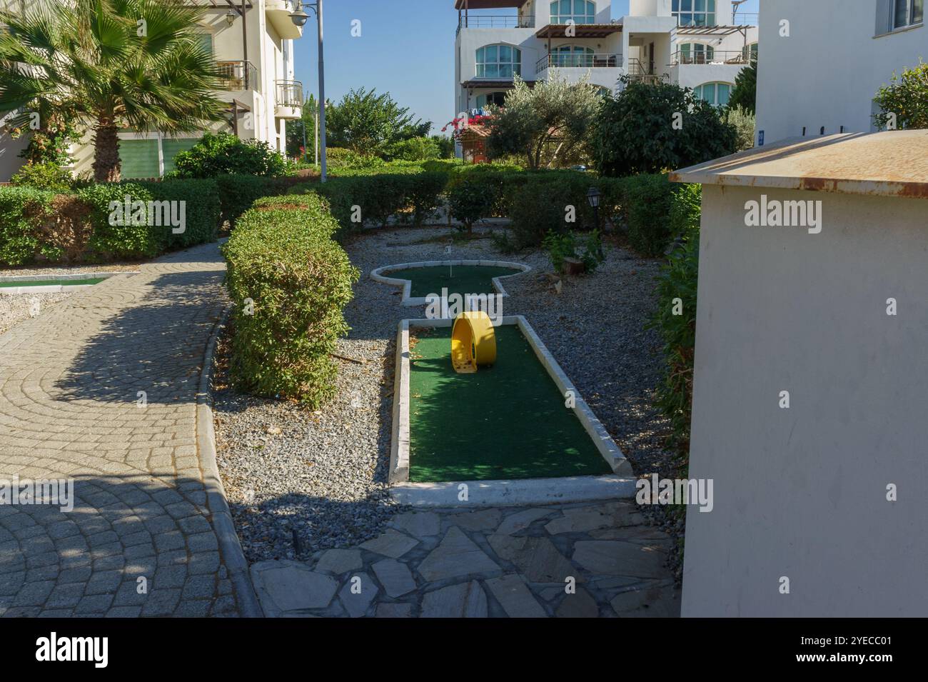 A serene mini-golf layout surrounded by lush greenery and bright ...