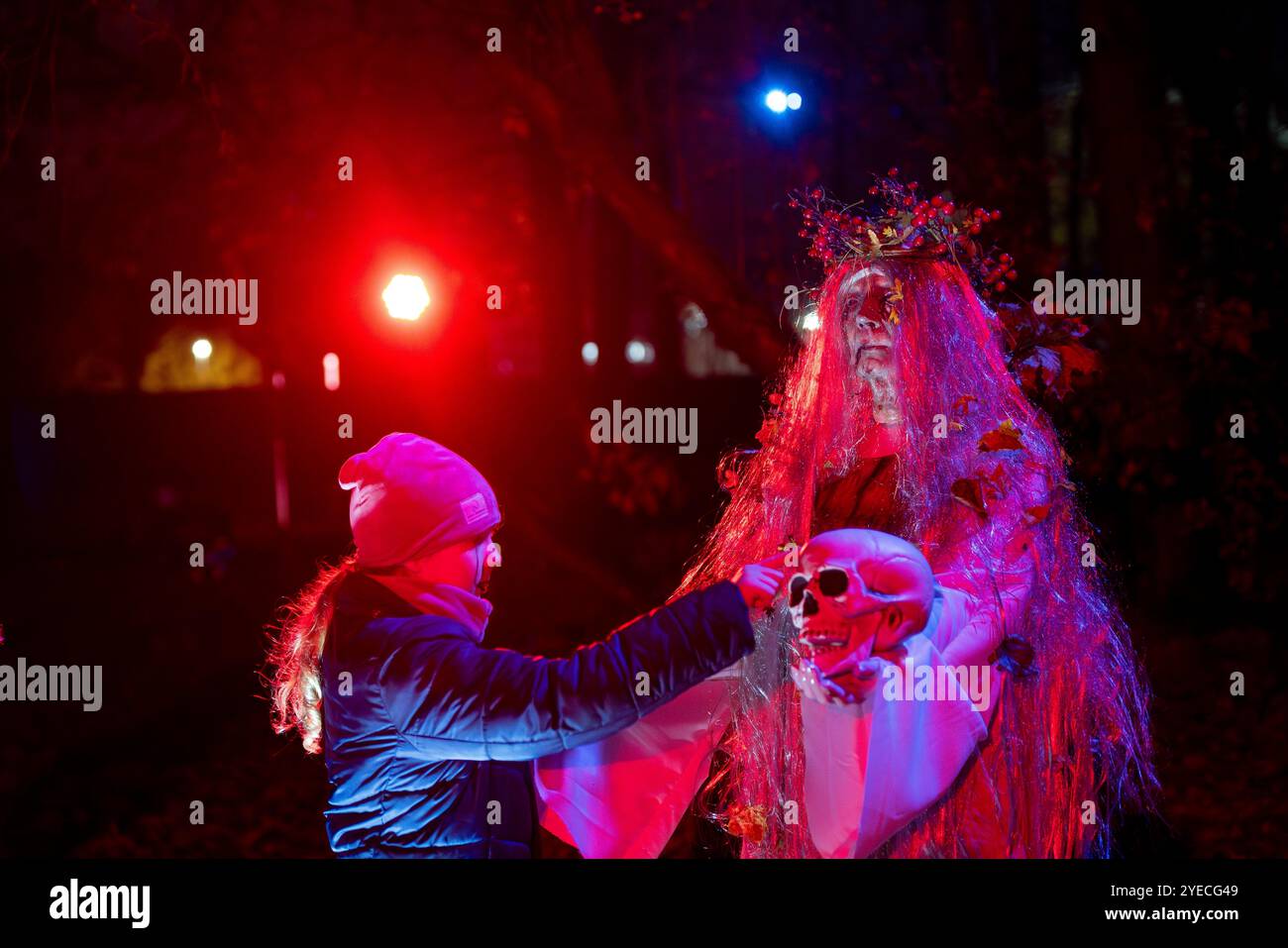 A girl examines the Halloween ghost statue in the park during a ...