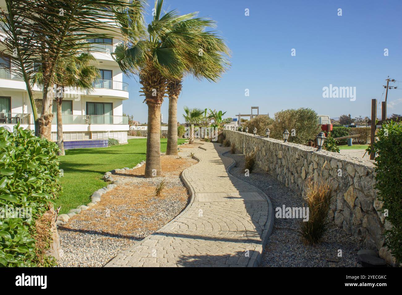 A winding path bordered by lush greenery leads to a tranquil seaside ...