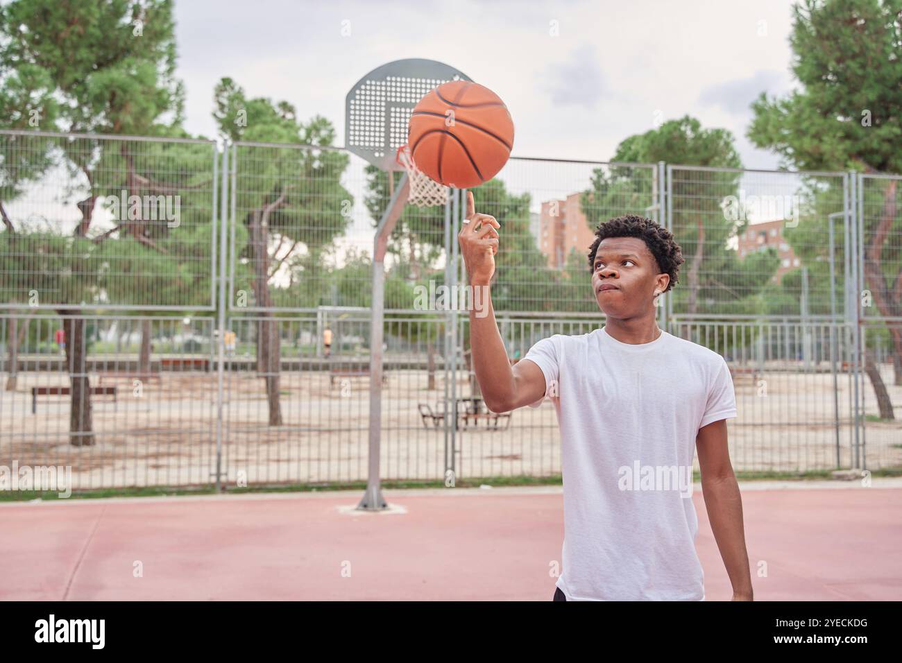 Teenage boy spinning basketball on his finger during training Stock ...