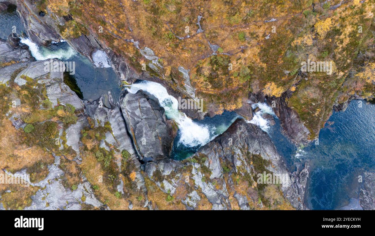 Aerial view of a waterfall cascading through rocky terrain surrounded ...